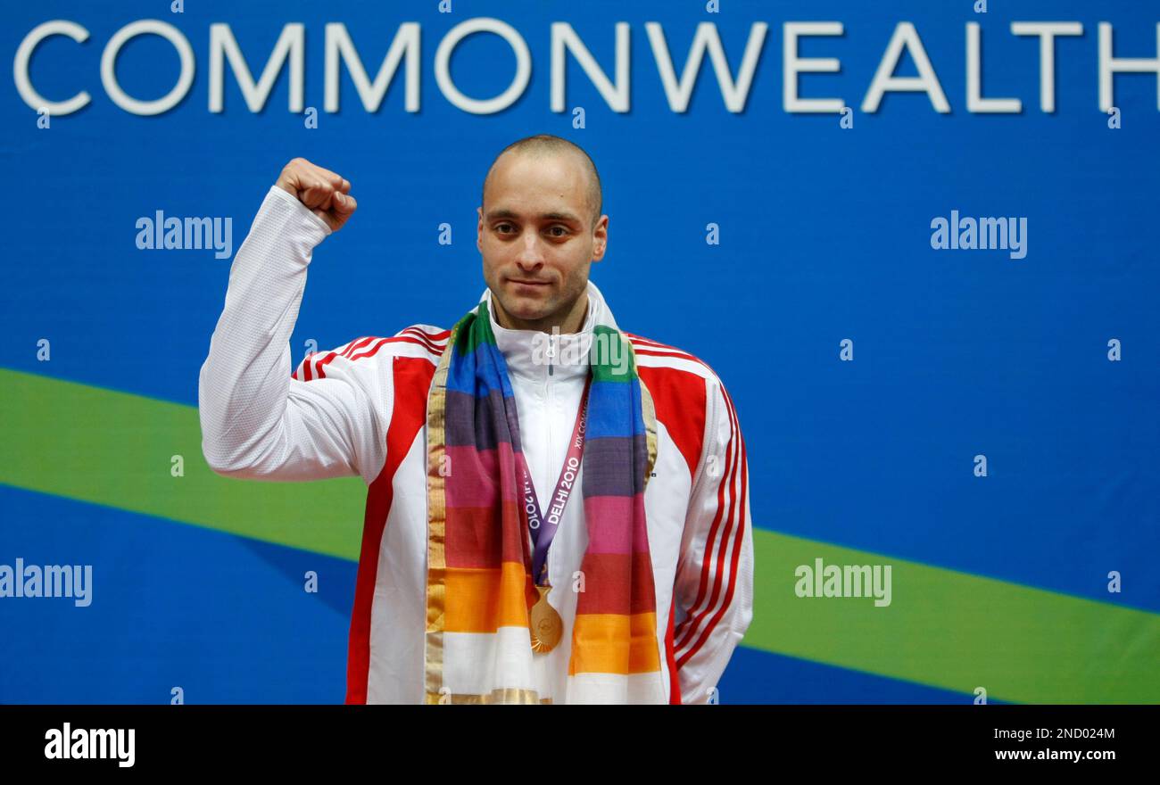 England's James Goddard poses with his gold medal on the podium ...