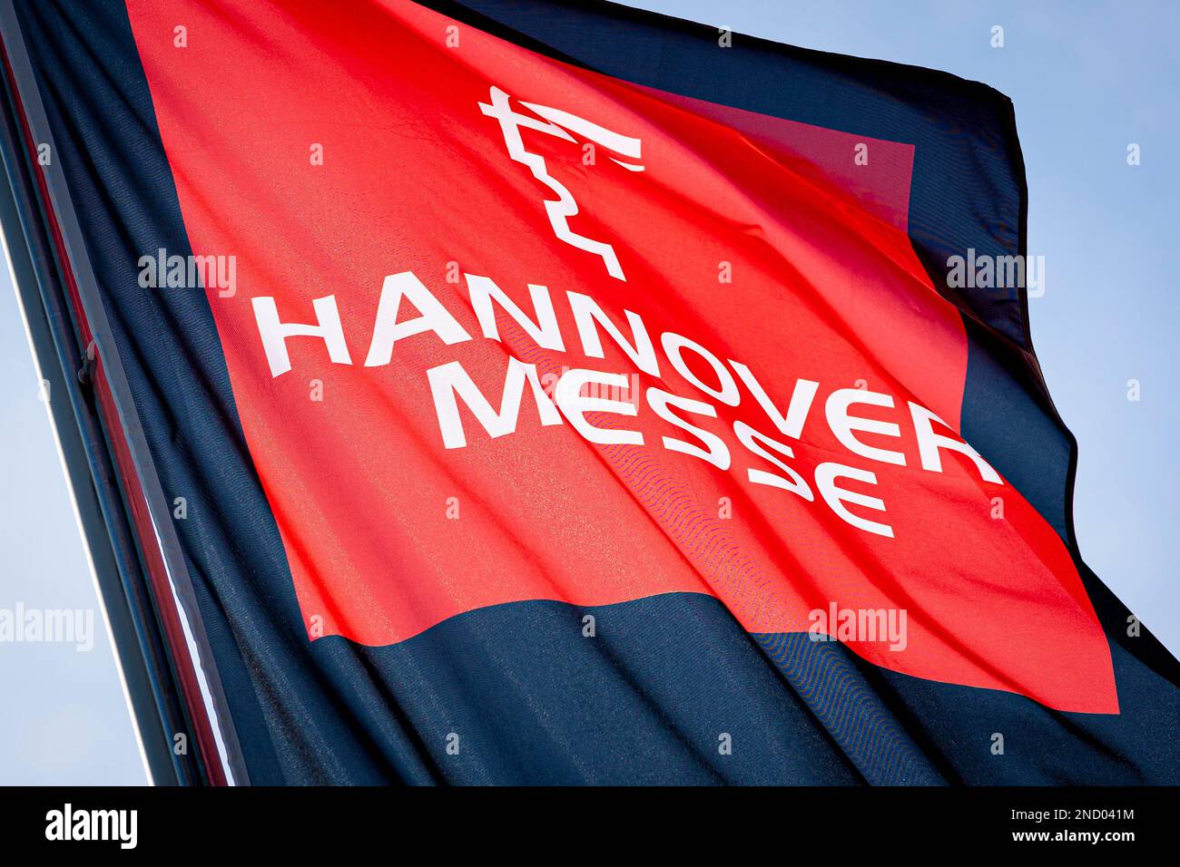 Hanover, Germany. 15th Feb, 2023. A flag for the Hannover Messe flies in the light of the sun on ...