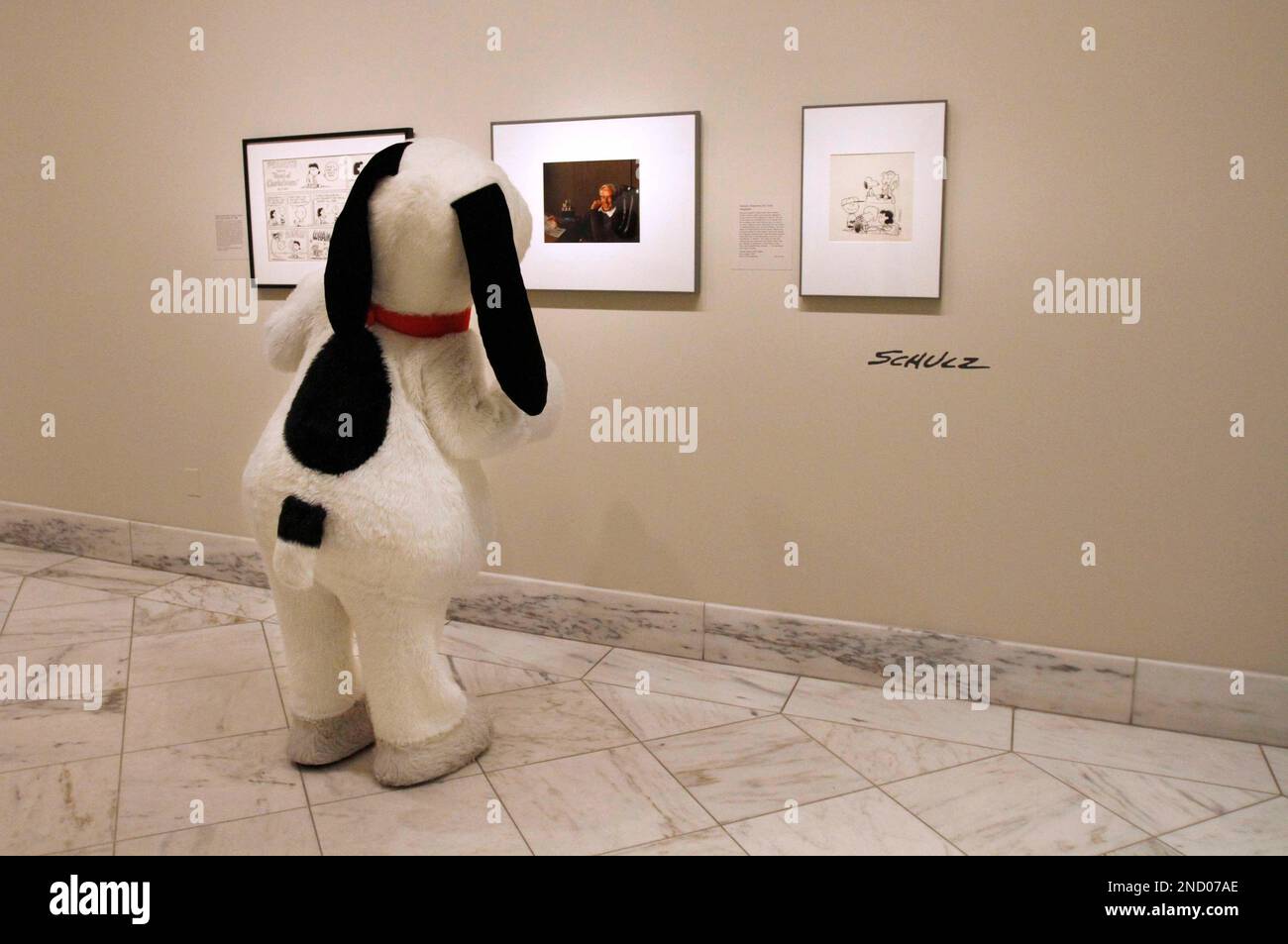 The character "Snoopy" looks at a portrait of Peanuts creator Charles M ...