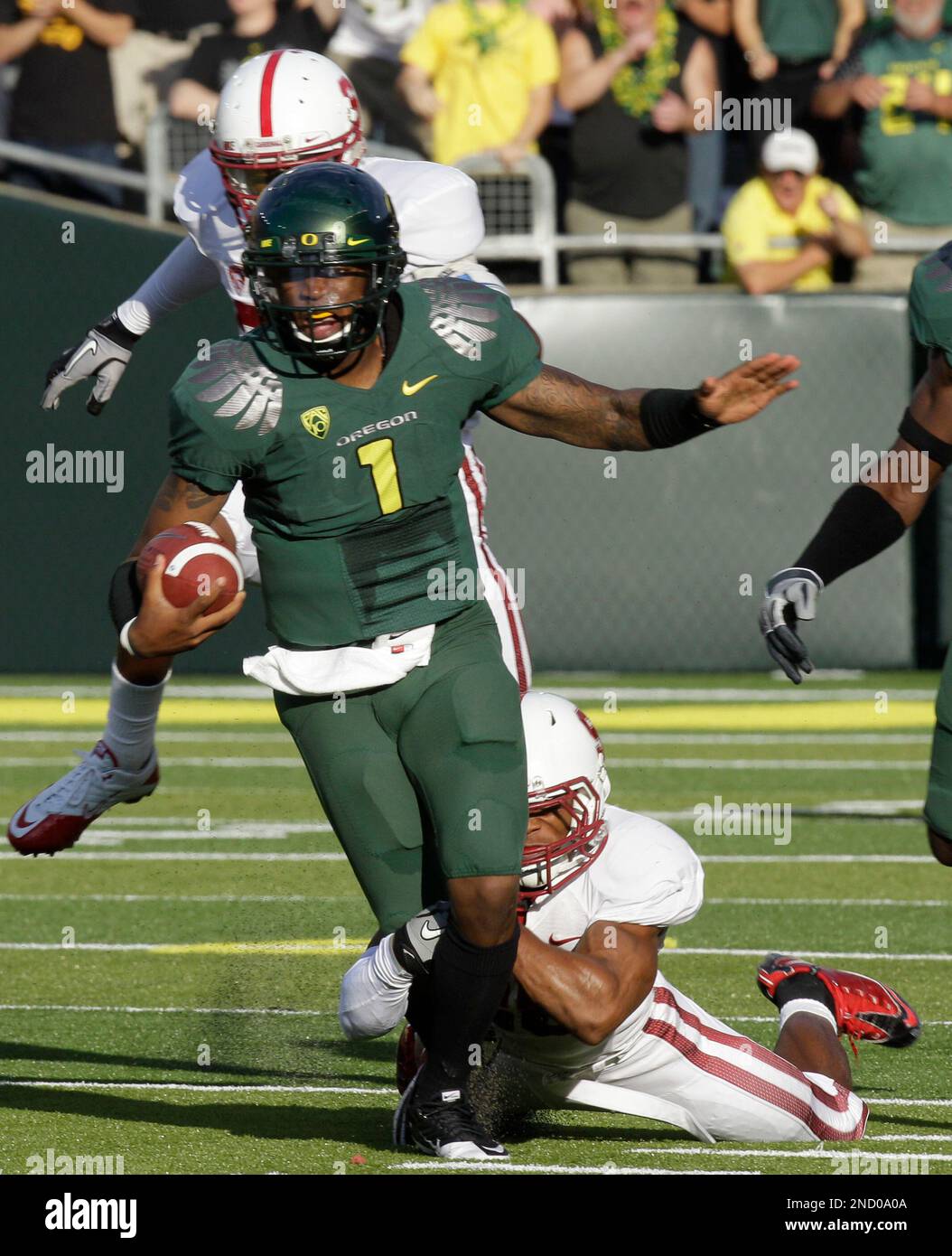 Oregon's quarterback Darron Thomas (1) is dragged down by Stanford's ...