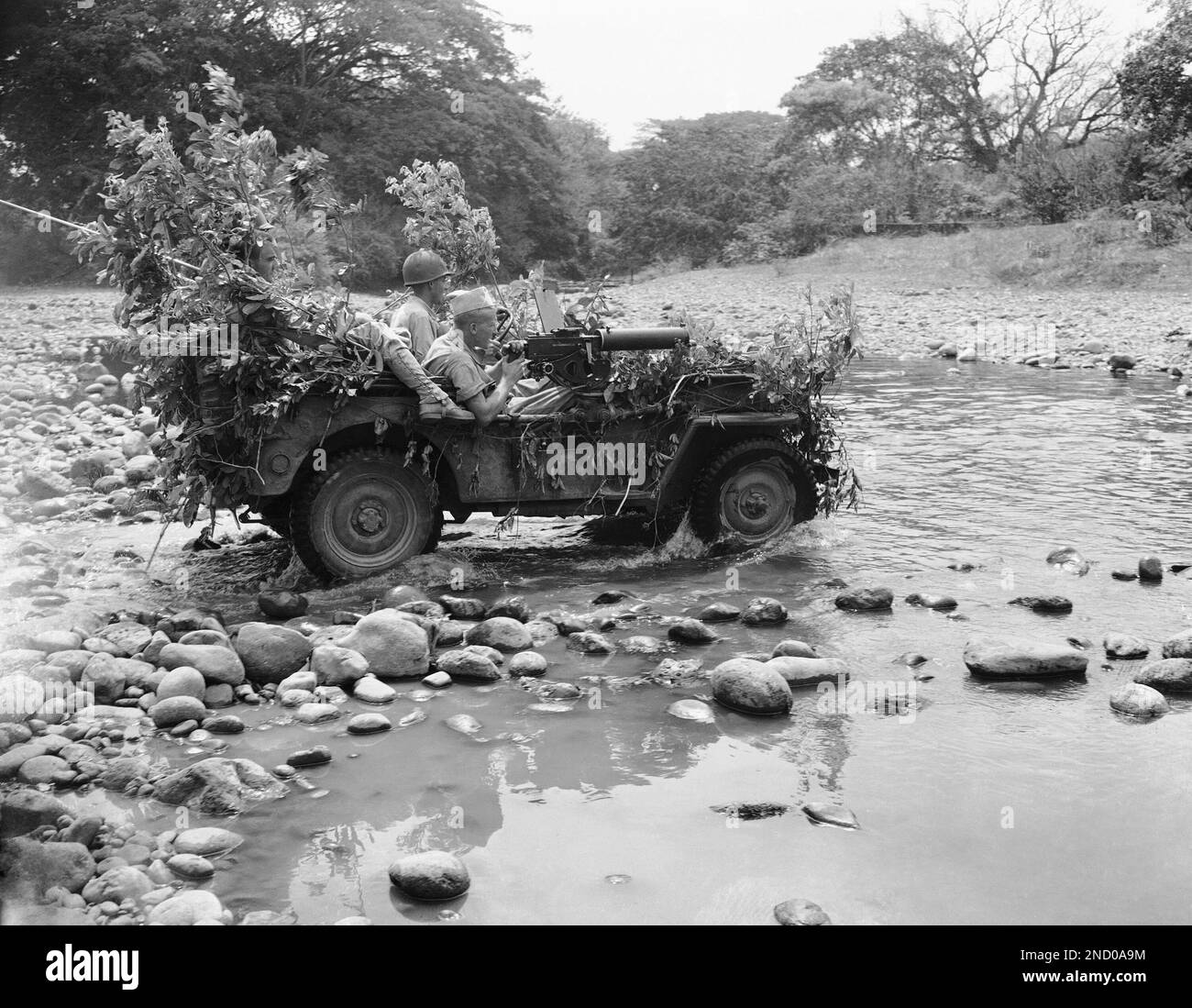 Crossing a jungle stream on its way up to the front, a powerful Army ...