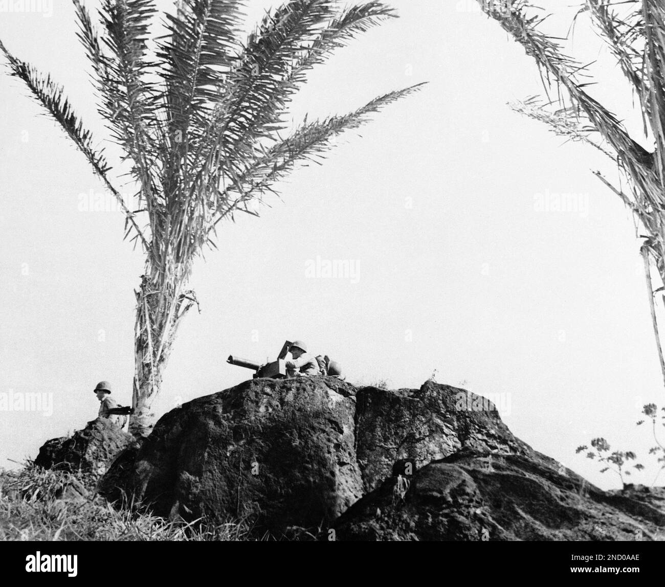 A “Yellow” army machine gun crew nests high on a rock in the mountains ...