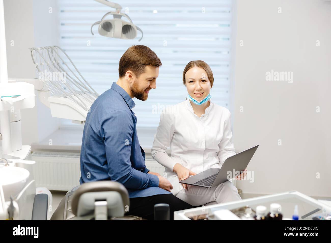 A handsome young man is talking to a female doctor at a dental ...
