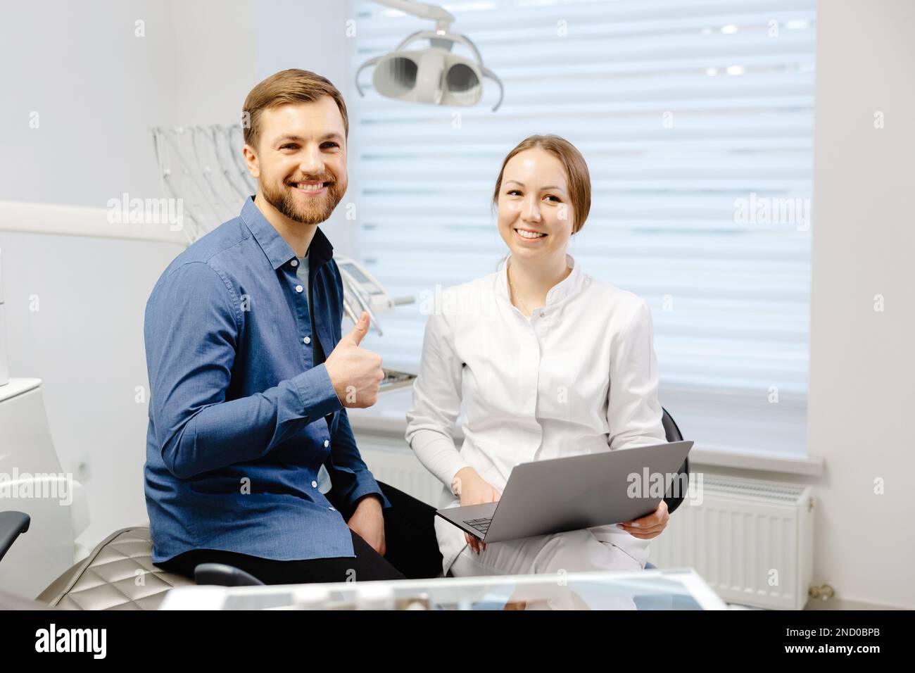 A handsome young man is talking to a female doctor at a dental ...