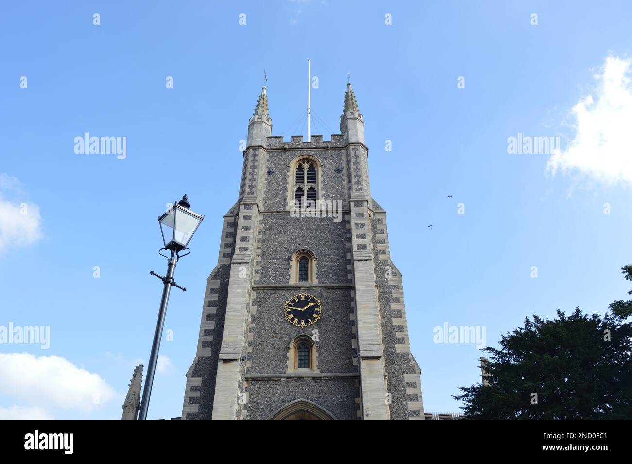 The Croydon Minster looming over a lamppost under a bright cloudy sky ...