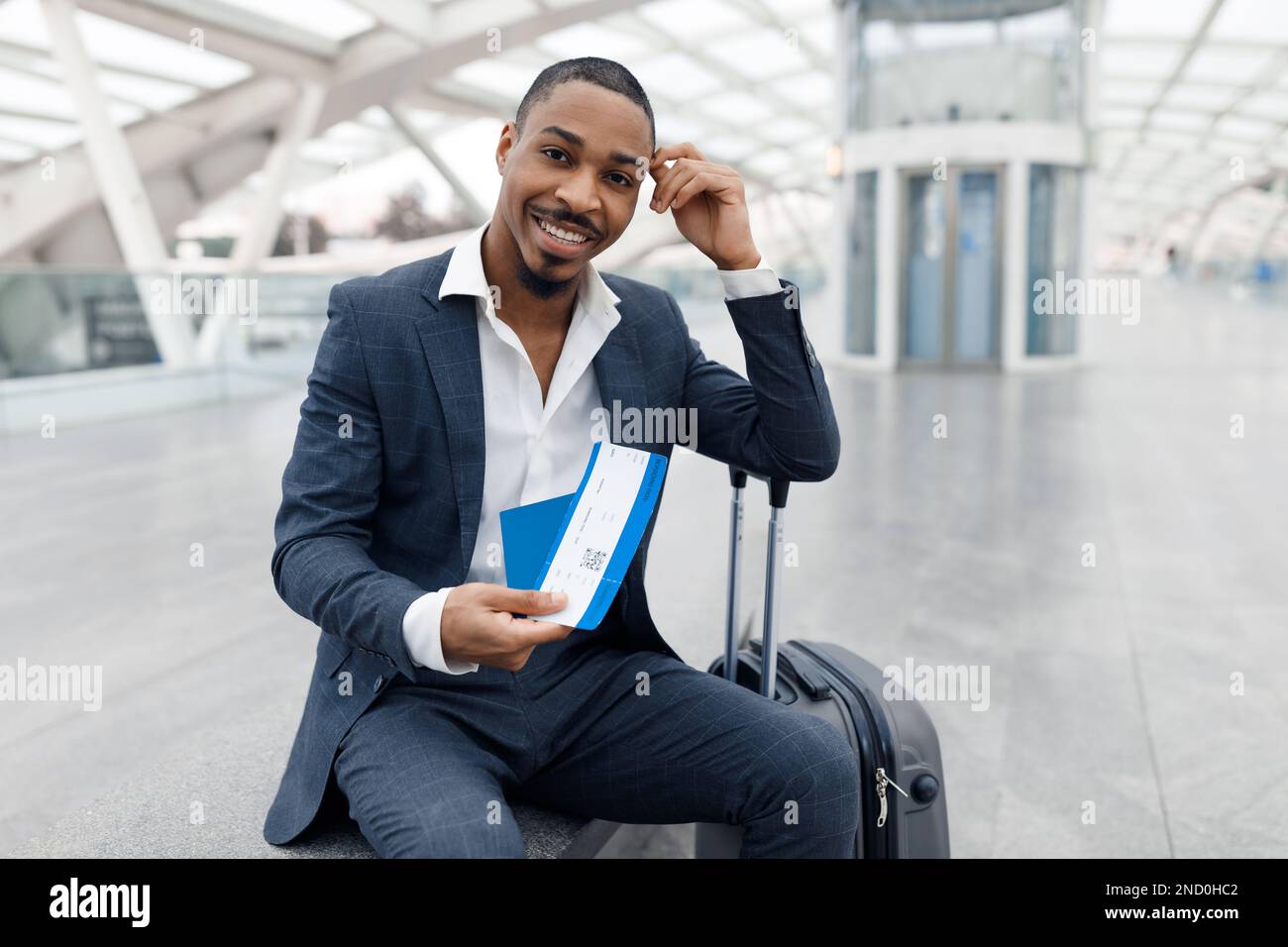 Happy Black Businessman Sitting On Bench At Airport, Waiting For His ...