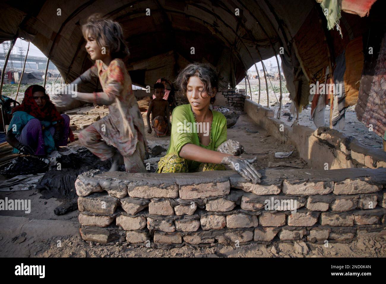 Pakistani women built boundary wall in their makeshift hut at a slum ...