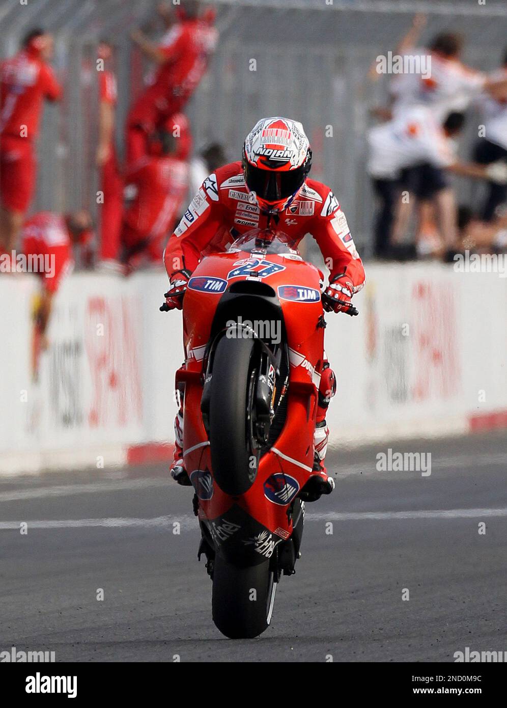 MotoGP Ducati rider Casey Stoner of Australia does wheelie as he ...