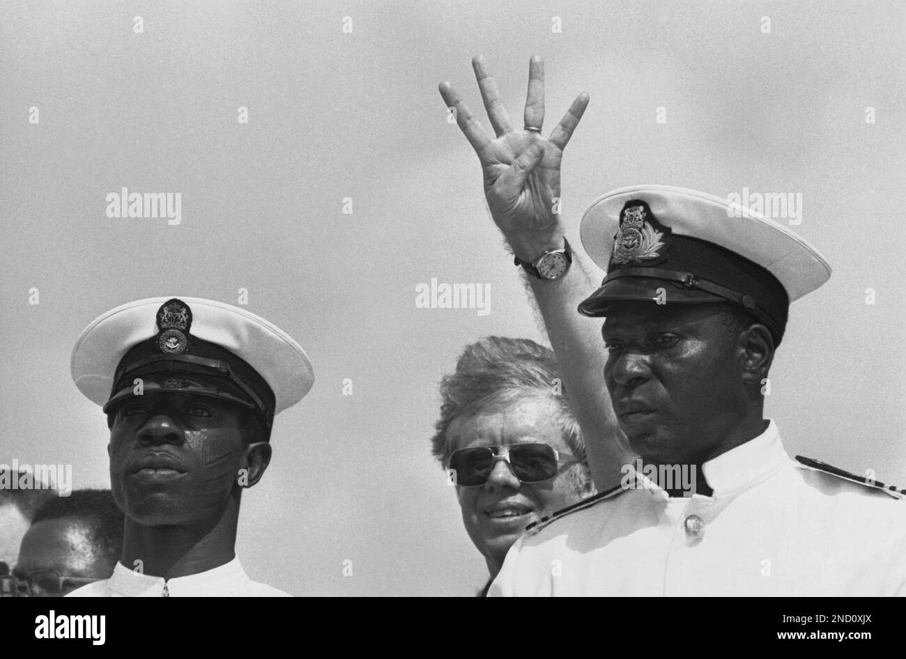 Flanked by two uniformed crewmen President Jimmy Carter holds up his ...