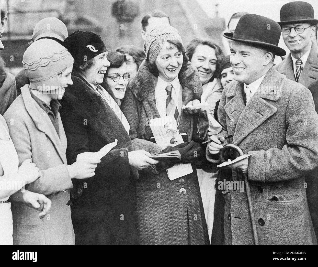 Charlie Chaplin greets a group of English admirers and signs autographs ...