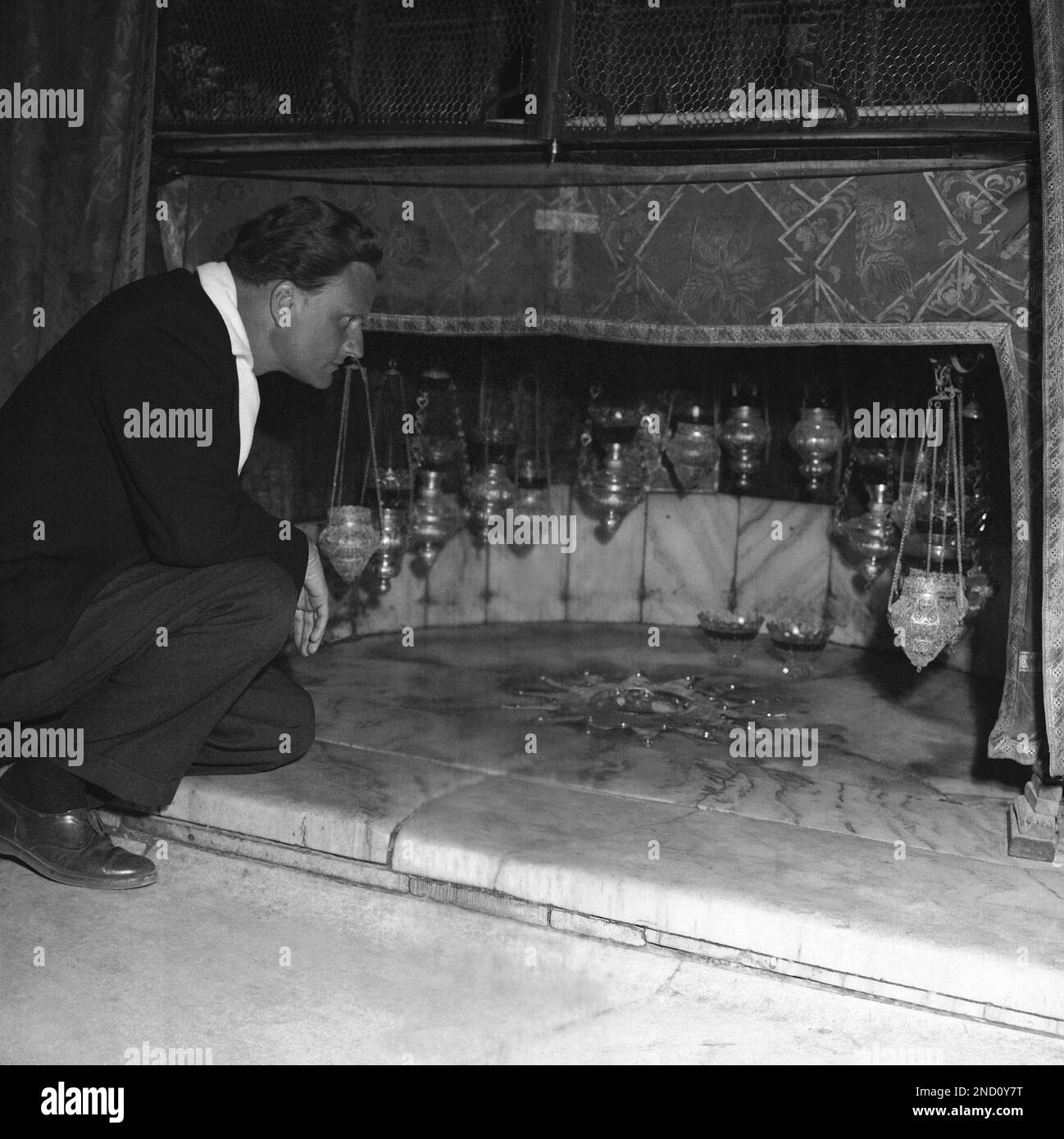 American evangelist Billy Graham kneels near the star in the Grotto of ...