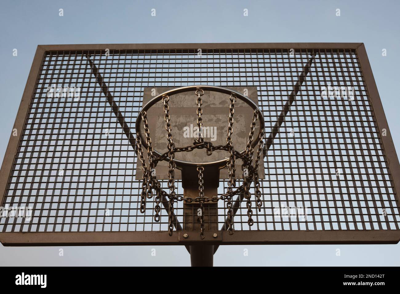 A vintage basketball hoop attached to a metal backboard, set against a ...