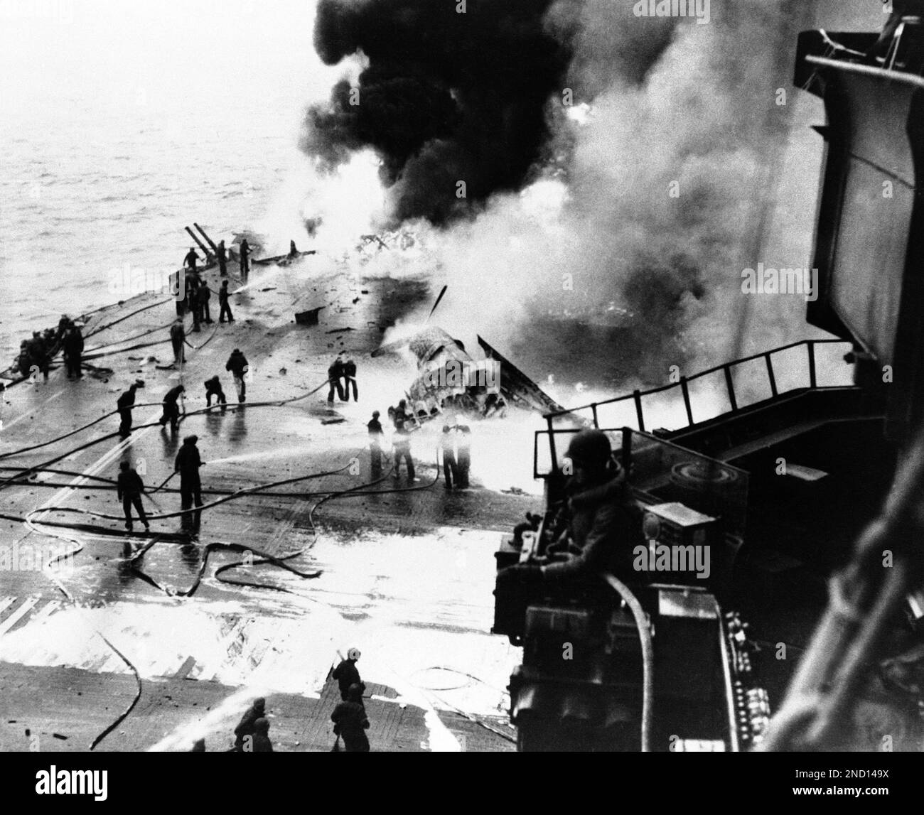Firefighting parties battle the flames raging on the flight deck of the ...