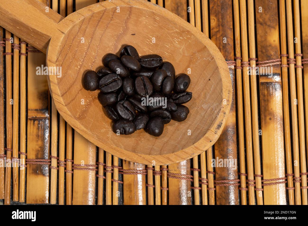 Wooden Spoon with whole beans on a reed mat Stock Photo - Alamy