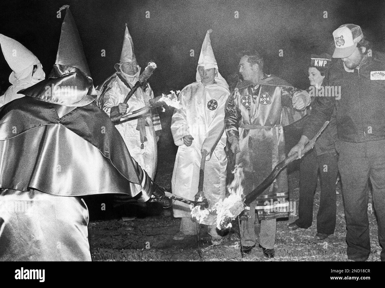 Members of the Ku Klux Klan light torches as they prepare to set a ...