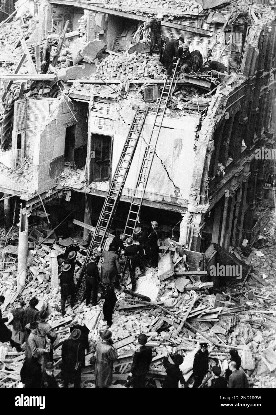 Rescue workers use ladders to reach a victim trapped on the third floor ...