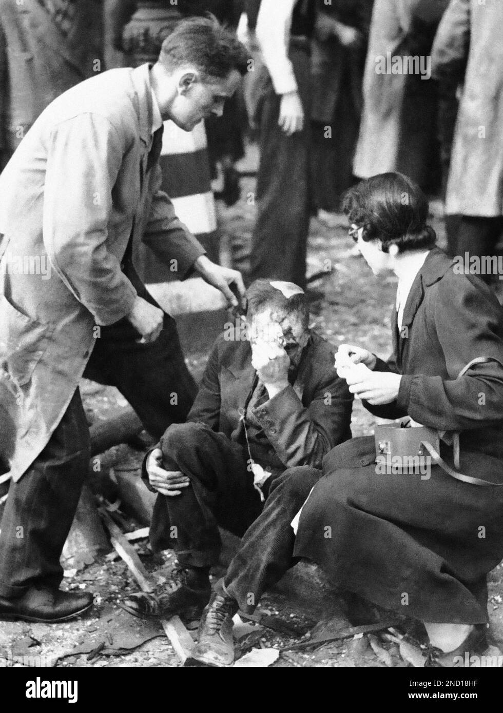 Rescuers give first aid to a civilian, injured when a German rocket V ...