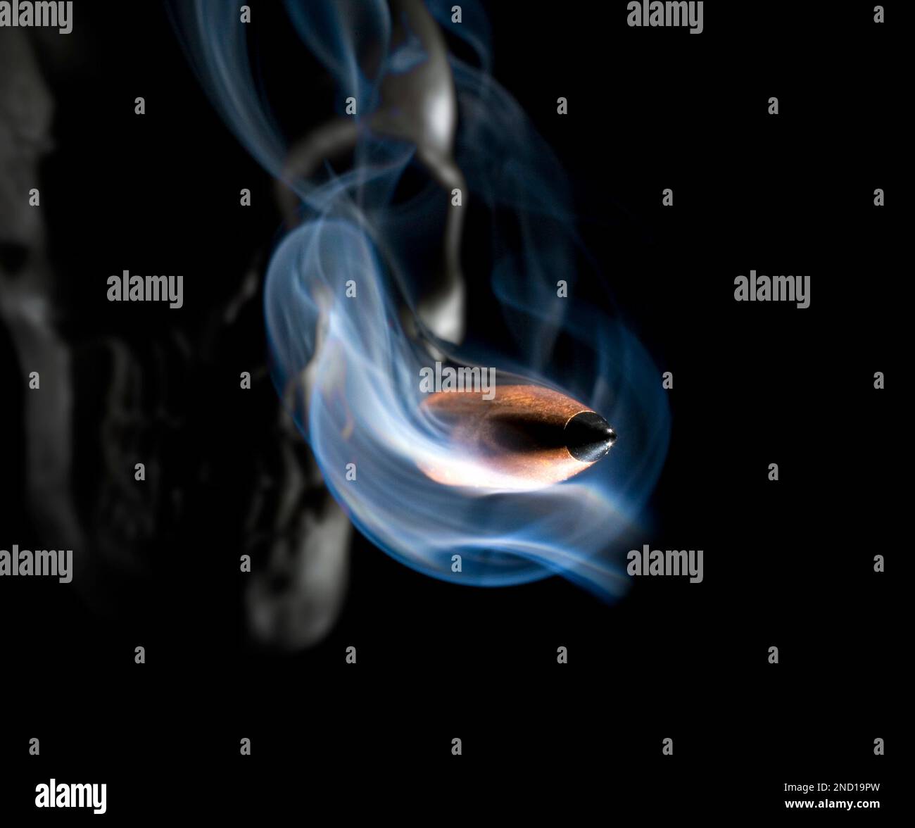 Bullet coming toward the camera with scary skull behind Stock Photo - Alamy