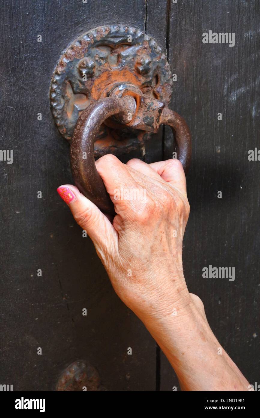 Female hand knocking a rusty old door knocker - John Gollop Stock Photo ...