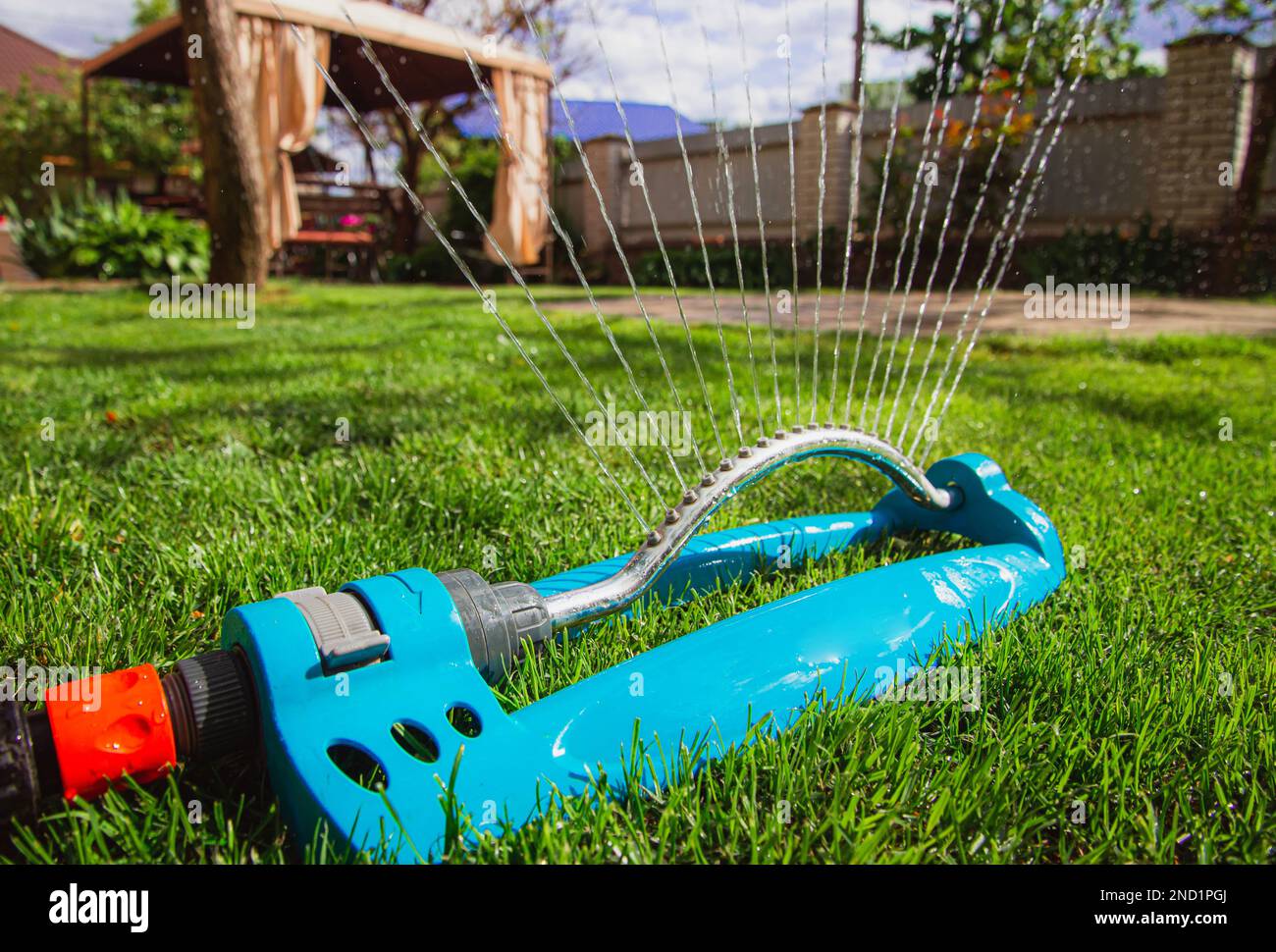 Modern oscillating sprinkler on the mown lawn in the garden Stock Photo ...