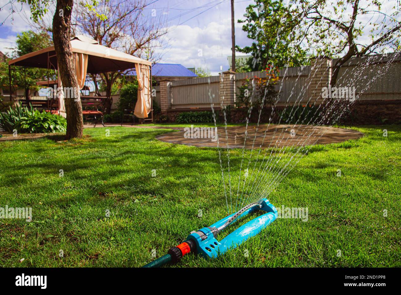Modern oscillating sprinkler on the mown lawn in the garden Stock Photo ...