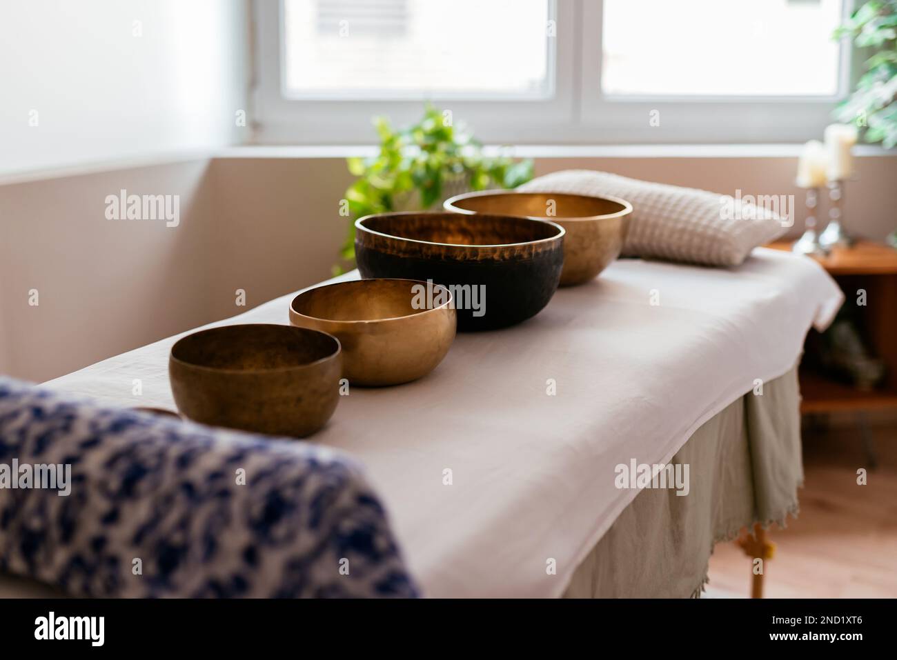 High angle of Tibetan singing bowls arranged in row on white massage ...