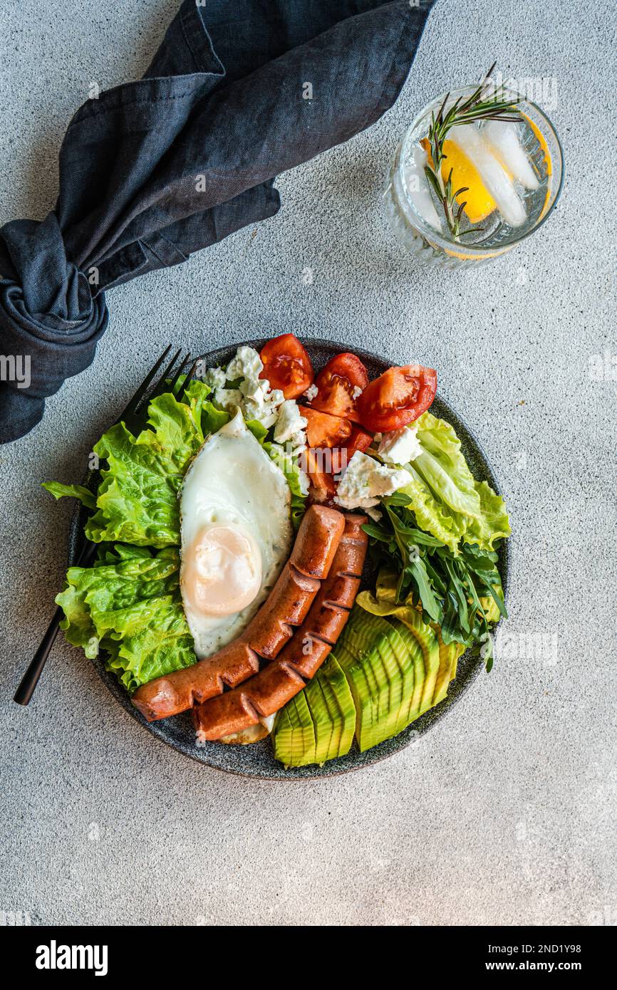 healthy ketogenic lunch plate with vegetables, fried egg and sausages ...