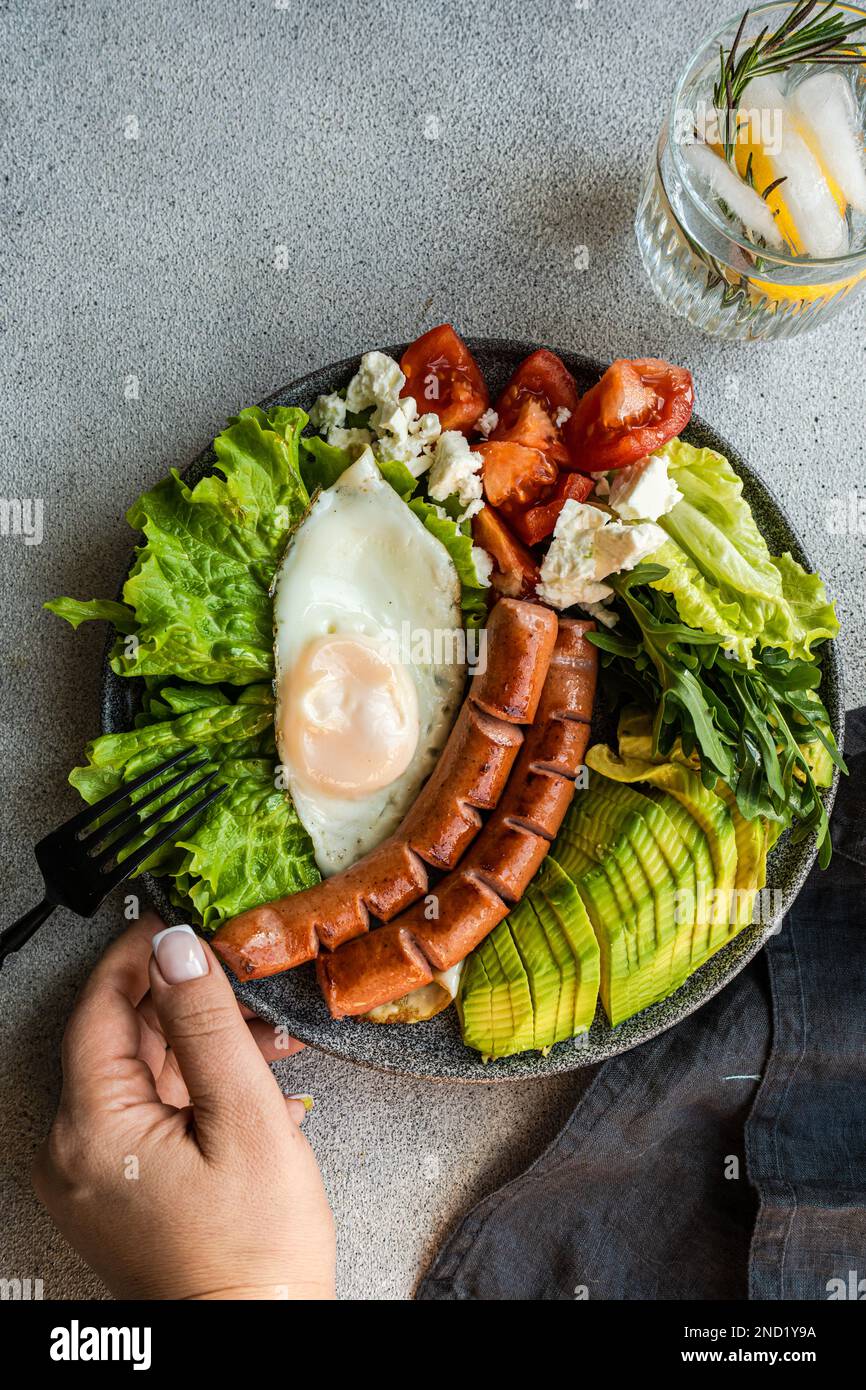 healthy ketogenic lunch plate with vegetables, fried egg and sausages ...