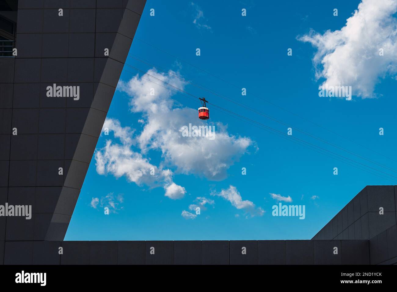 Low angle of bright ropeway cabin against blue cloudy sky over ...