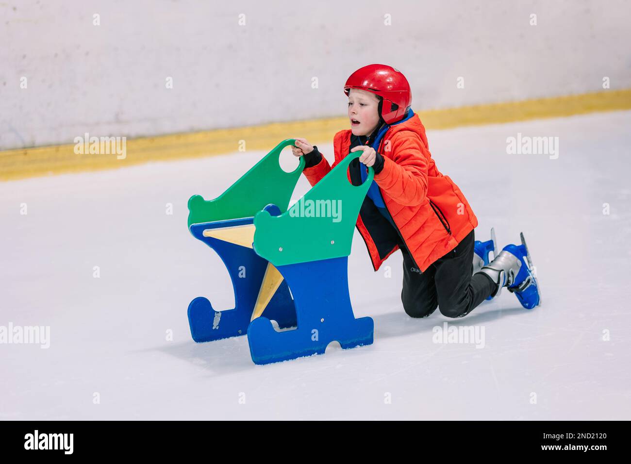 Full body of adorable boy in warm clothes and protective helmet with ...