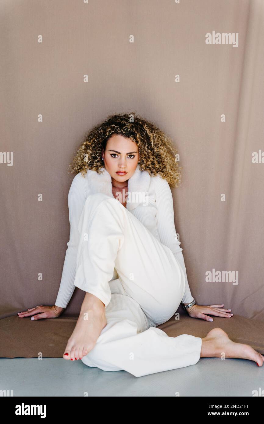 Full body high angle of young curly haired female in white outfit ...
