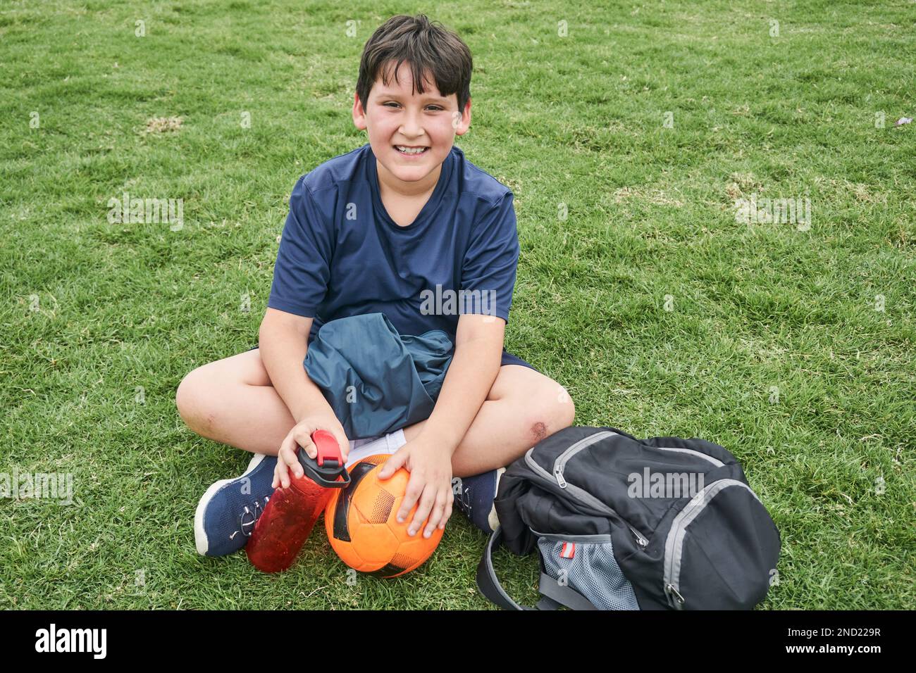 High angle full body of positive preteen boy in sportswear smiling and ...