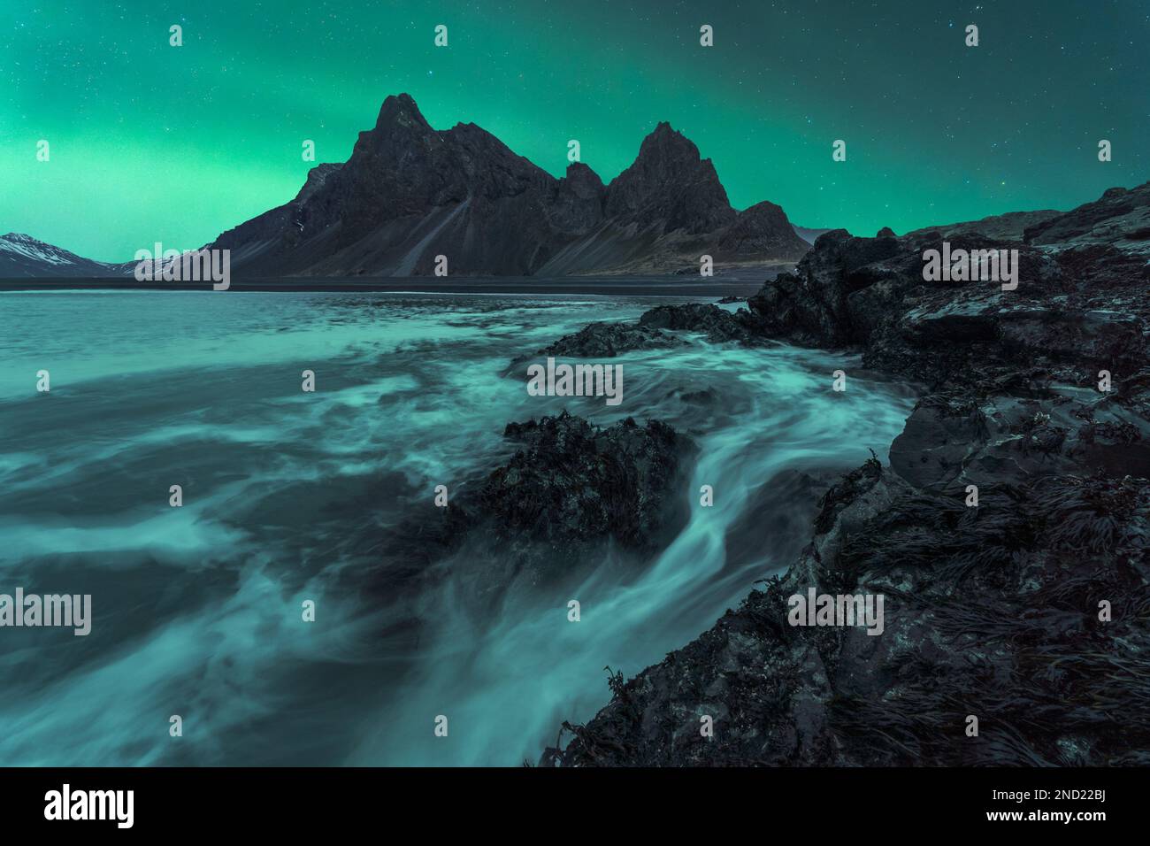Amazing view of green aurora borealis shining in night sky over snowy ...