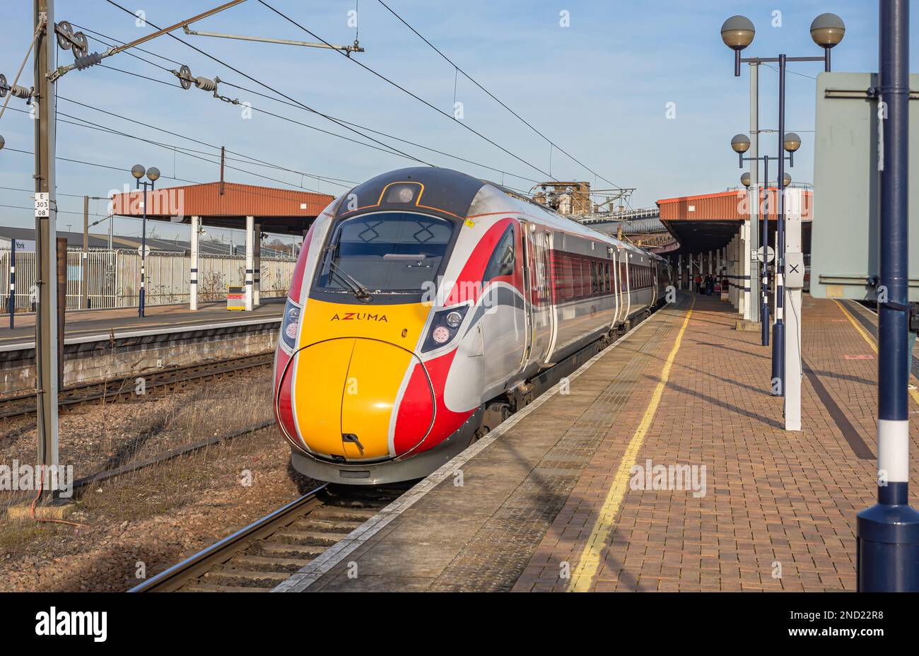 A view of a railway station with a train arriving at a platform. Power ...