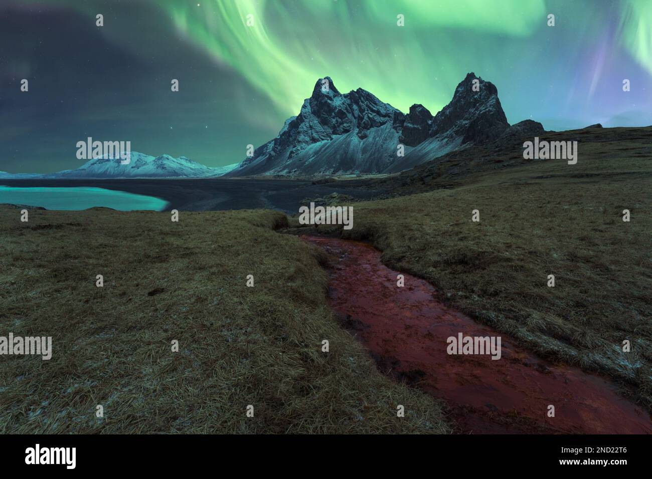 Amazing view of green aurora borealis shining in night sky over snowy ...