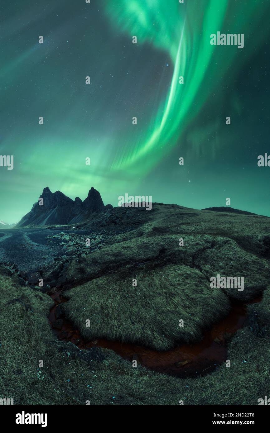 Amazing view of green aurora borealis shining in night sky over snowy ...