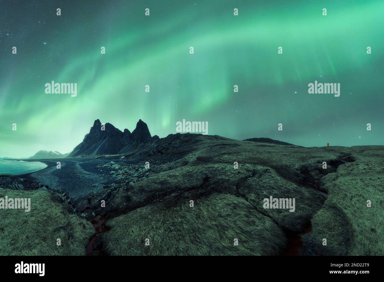 Amazing view of green aurora borealis shining in night sky over snowy ...