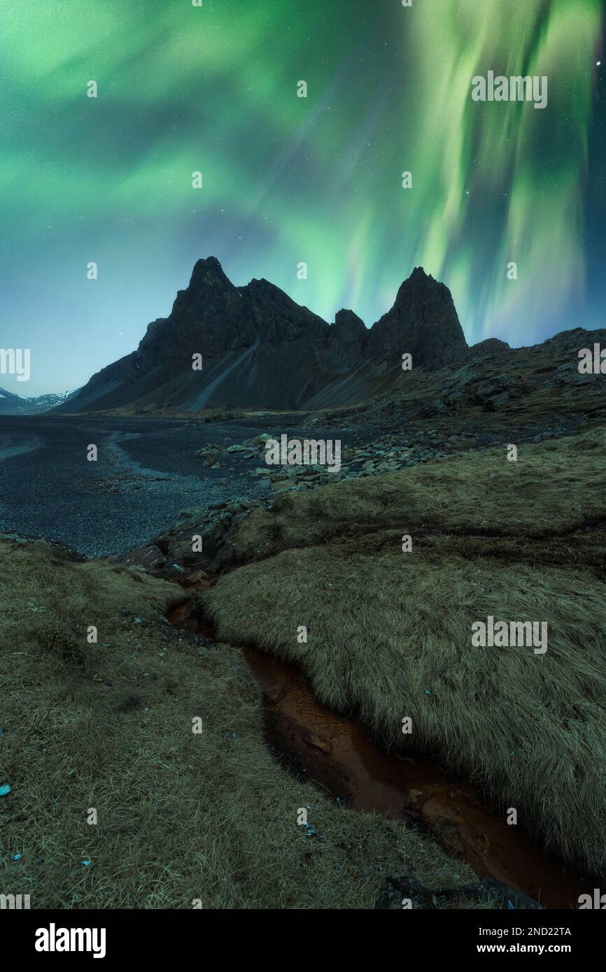 Amazing view of green aurora borealis shining in night sky over snowy ...
