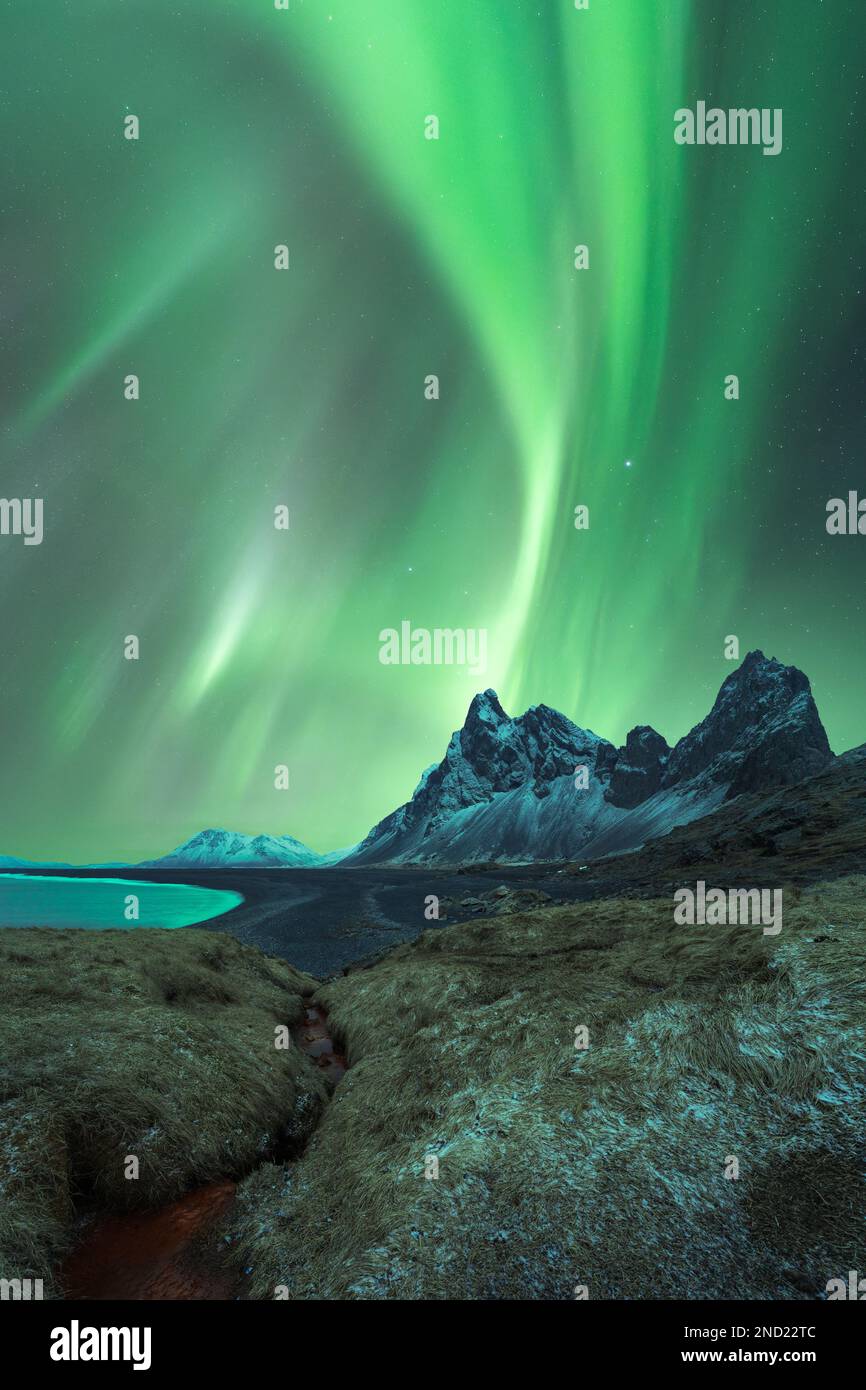 Amazing view of green aurora borealis shining in night sky over snowy ...