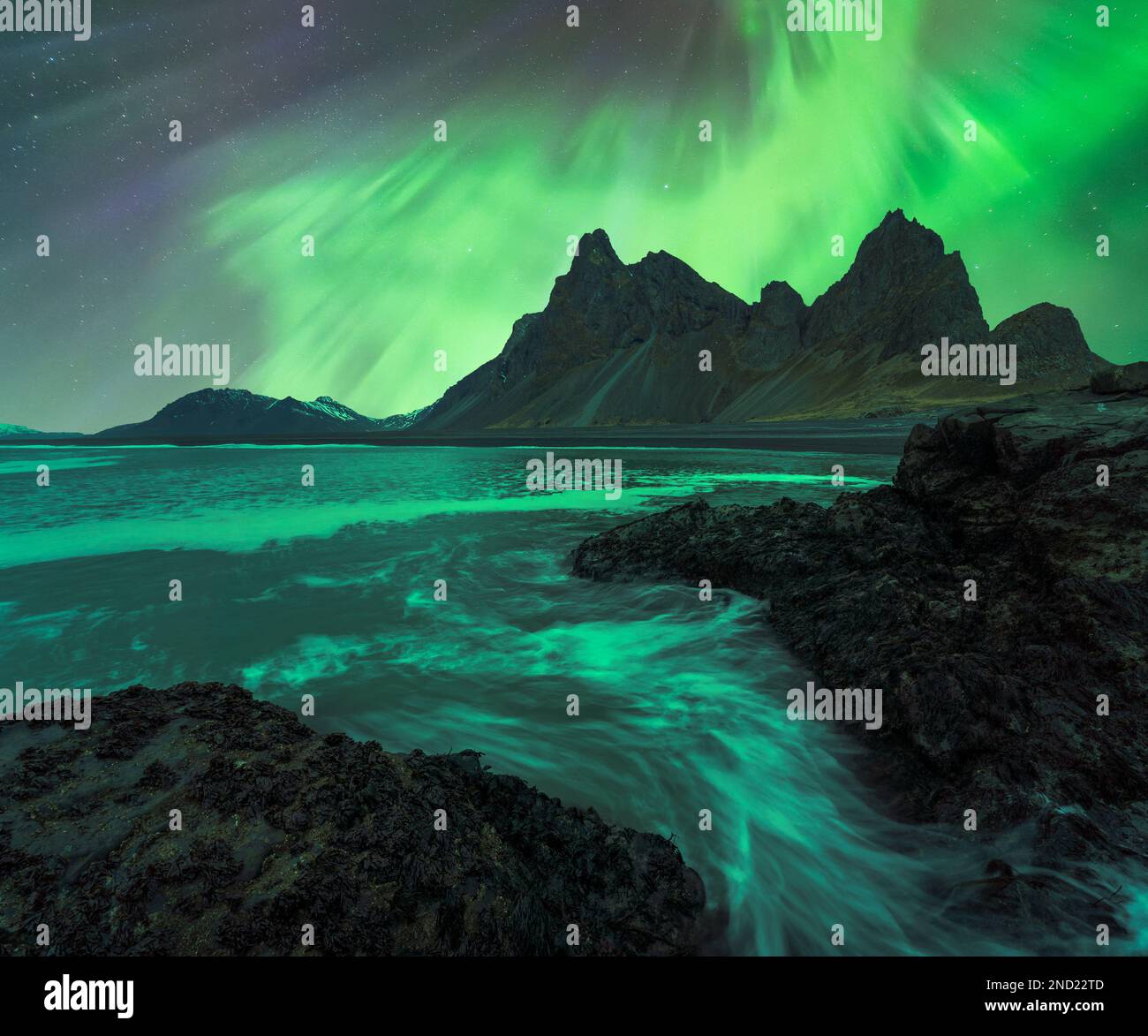Amazing view of green aurora borealis shining in night sky over snowy ...