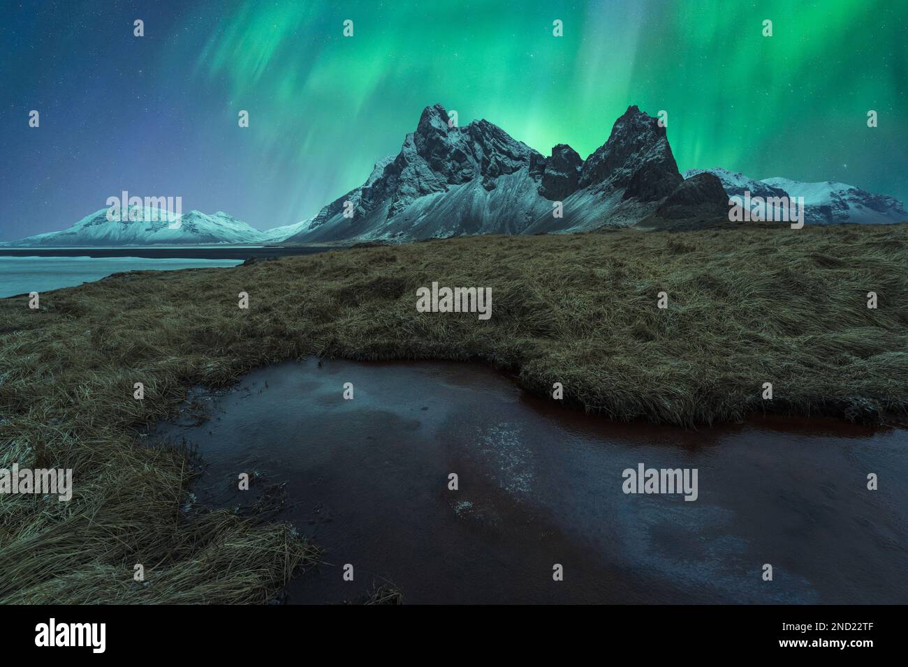 Amazing view of green aurora borealis shining in night sky over snowy ...