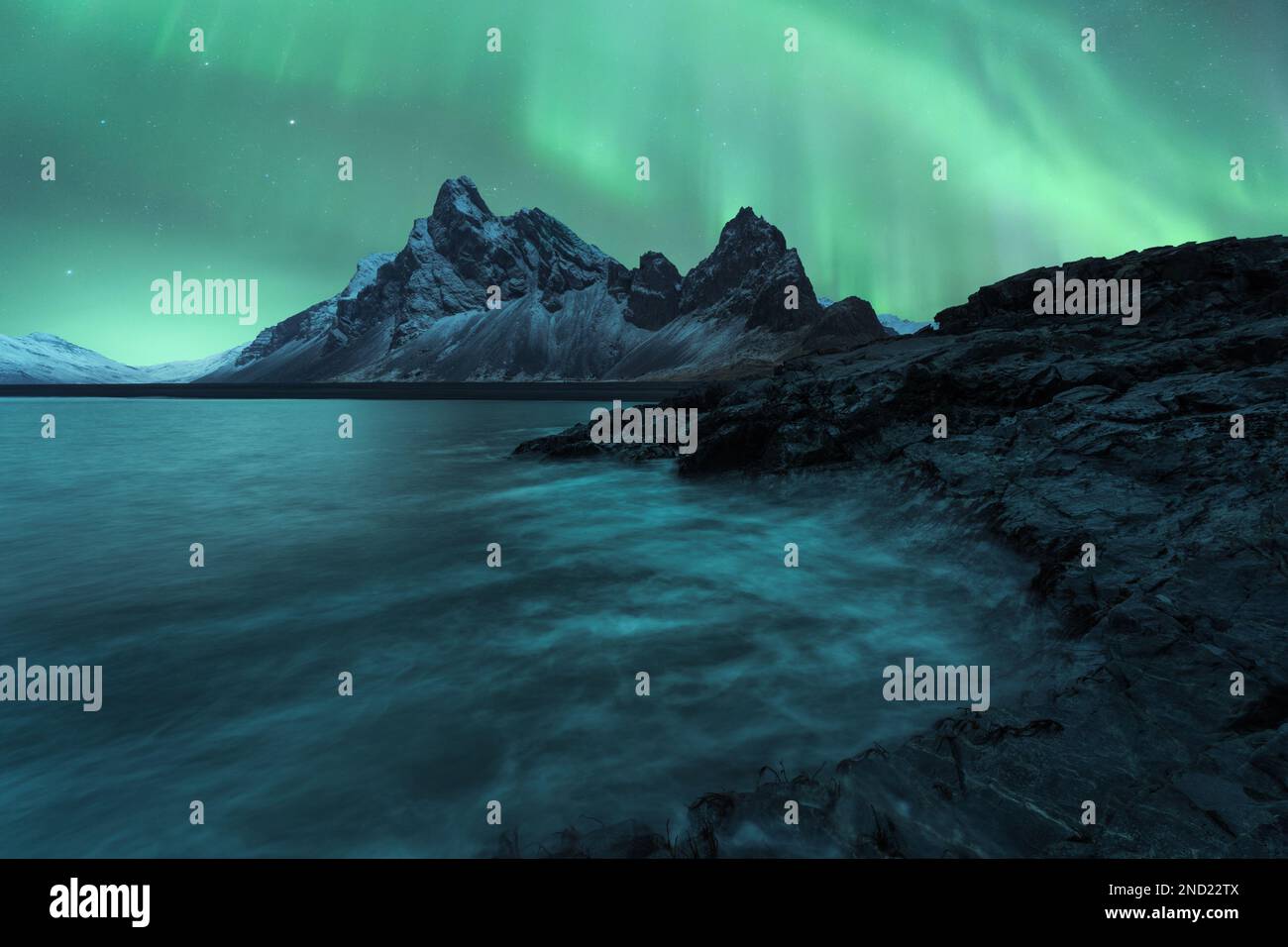 Amazing view of green aurora borealis shining in night sky over snowy ...