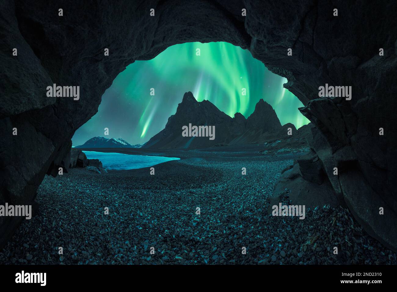 Amazing view from rocky cave of green aurora borealis shining in night ...