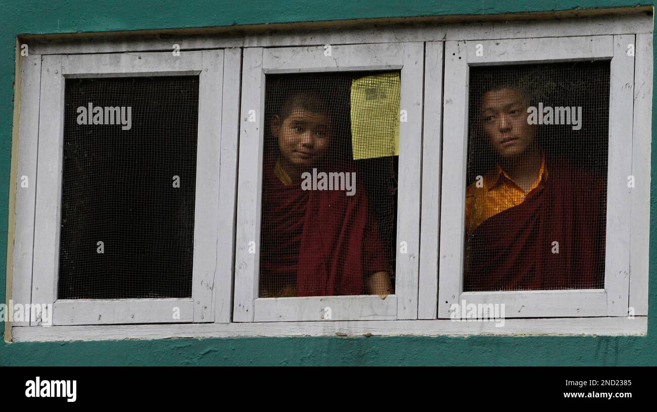 Buddhist Monks watch supporters of Ogyen Trinley Dorje, the head of the ...