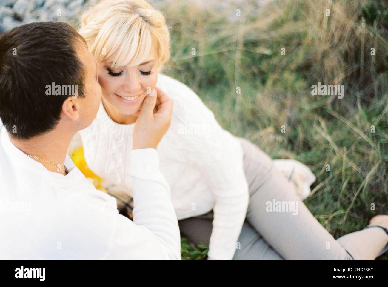Man touches woman face with his hand and kisses her on the cheek Stock ...