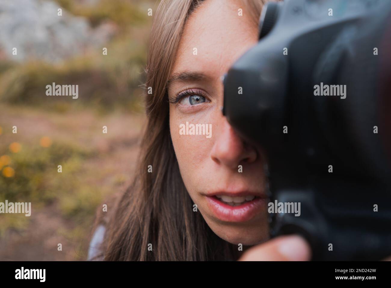 High angle of crop female photographer hiding behind professional photo ...