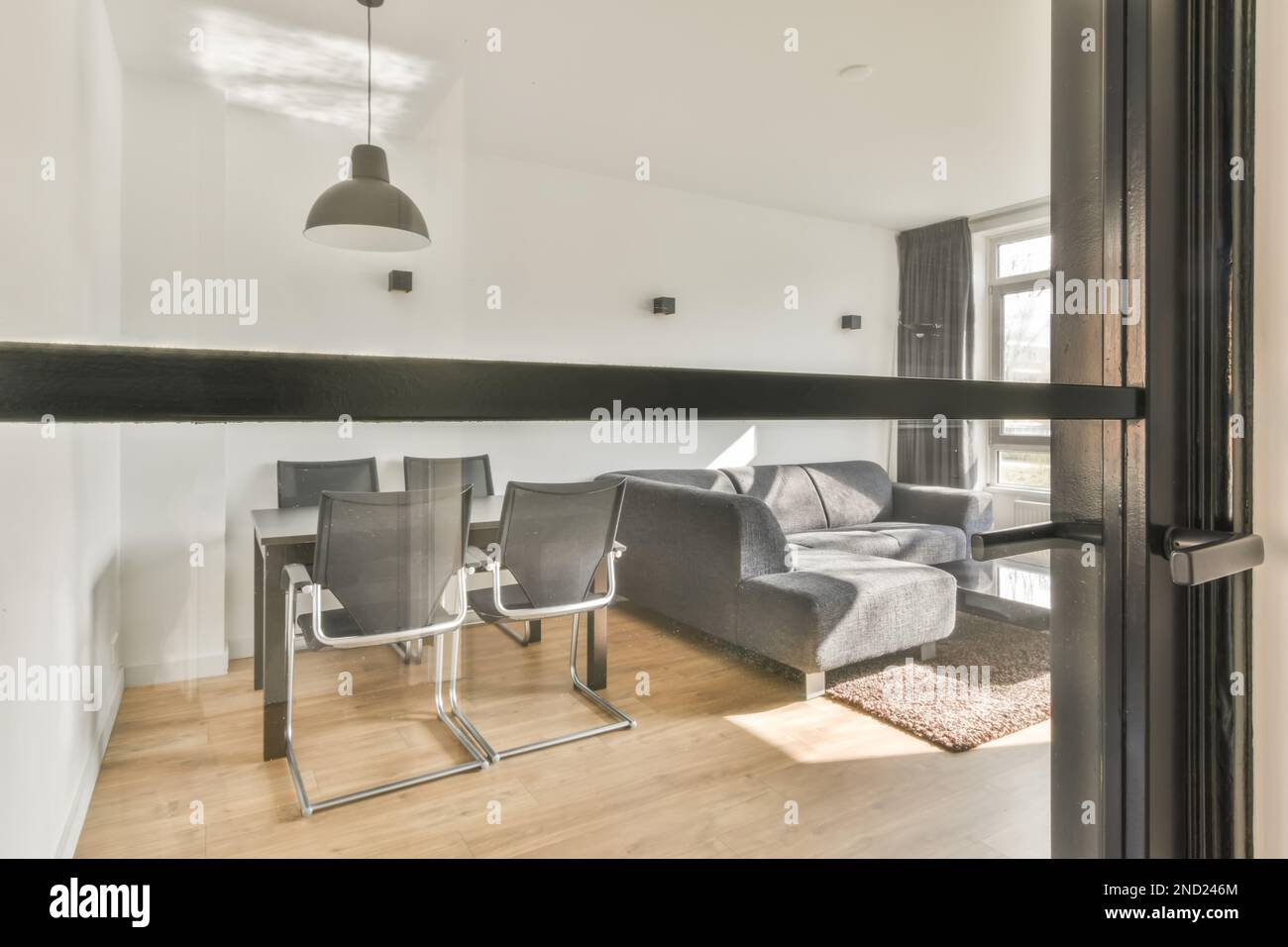 View through glass door of modern lounge with dining table chairs gray ...