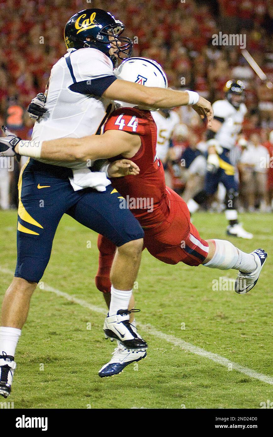 California's starting quarterback Kevin Riley (13) is hit by Arizona's ...