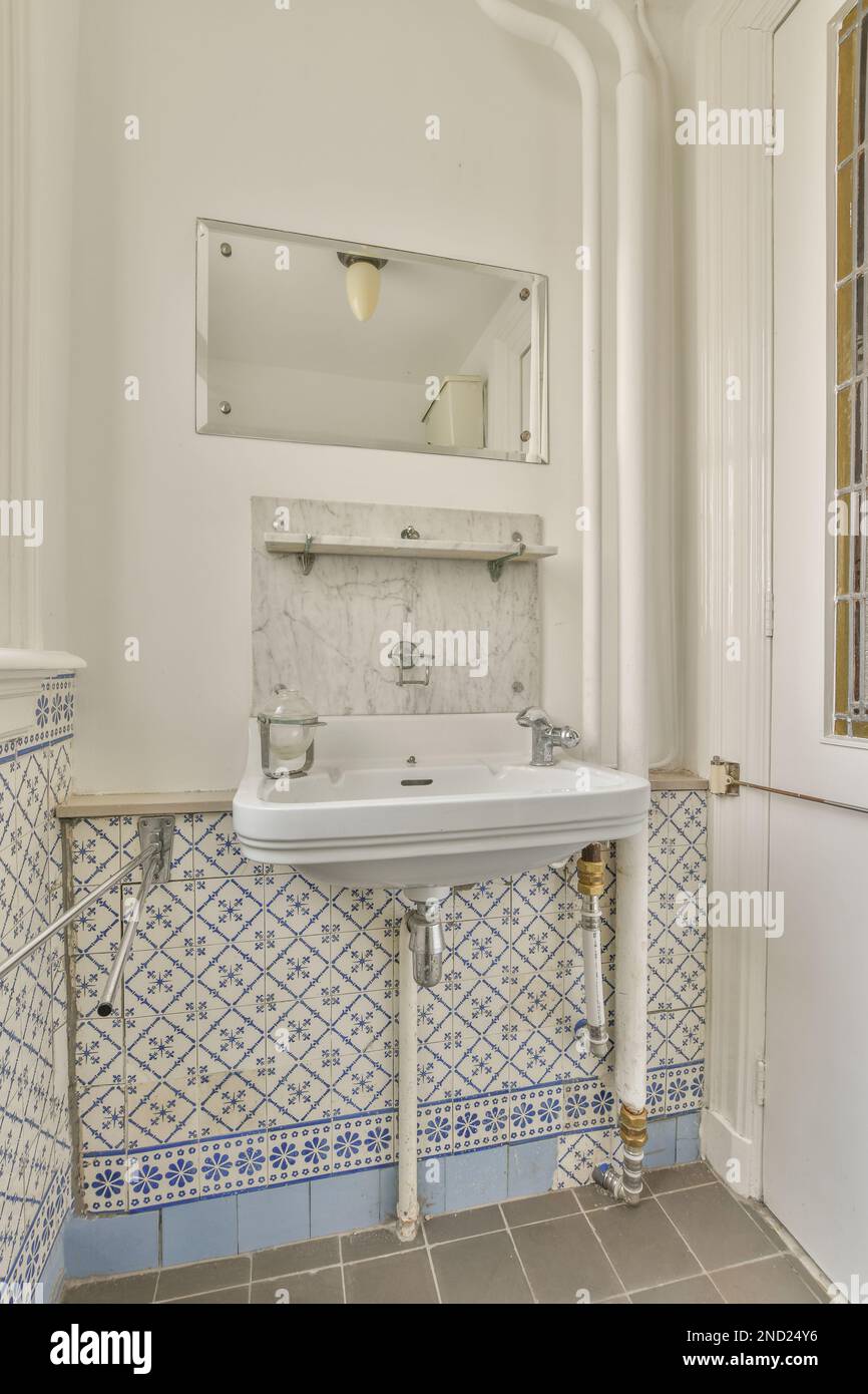 Modern bathroom with tiled walls and mirror hanging above sink with ...
