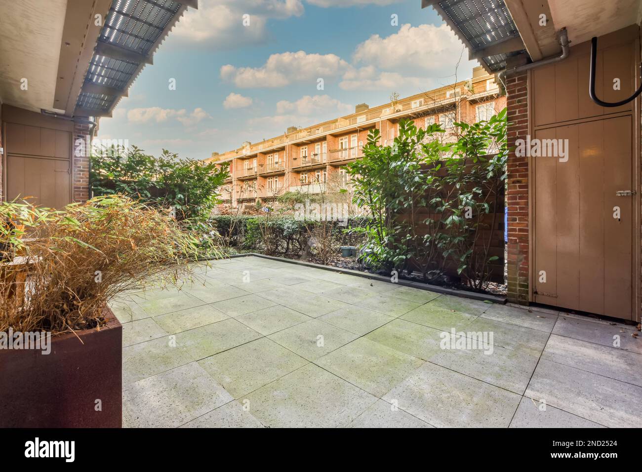 Wide angle of tiled terrace with glass window overlooking lush greenery ...